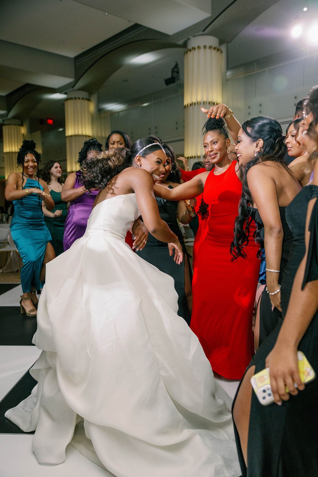Bride in Flowing A-Line Gown Dancing With Friends on Checkered Dance Floor