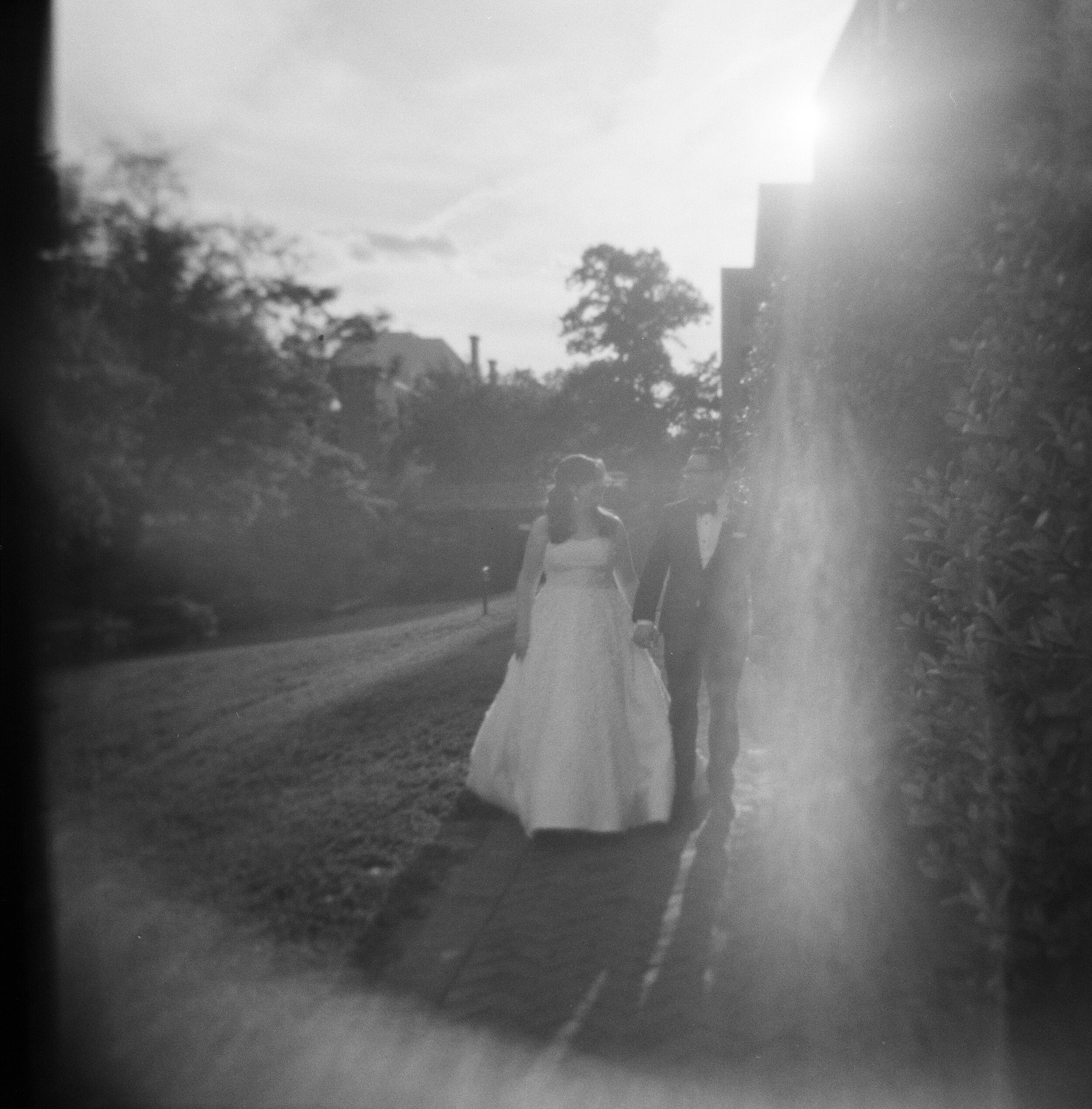 Black-and-White, Ethereal Photo of Bride and Groom Walking Outside
