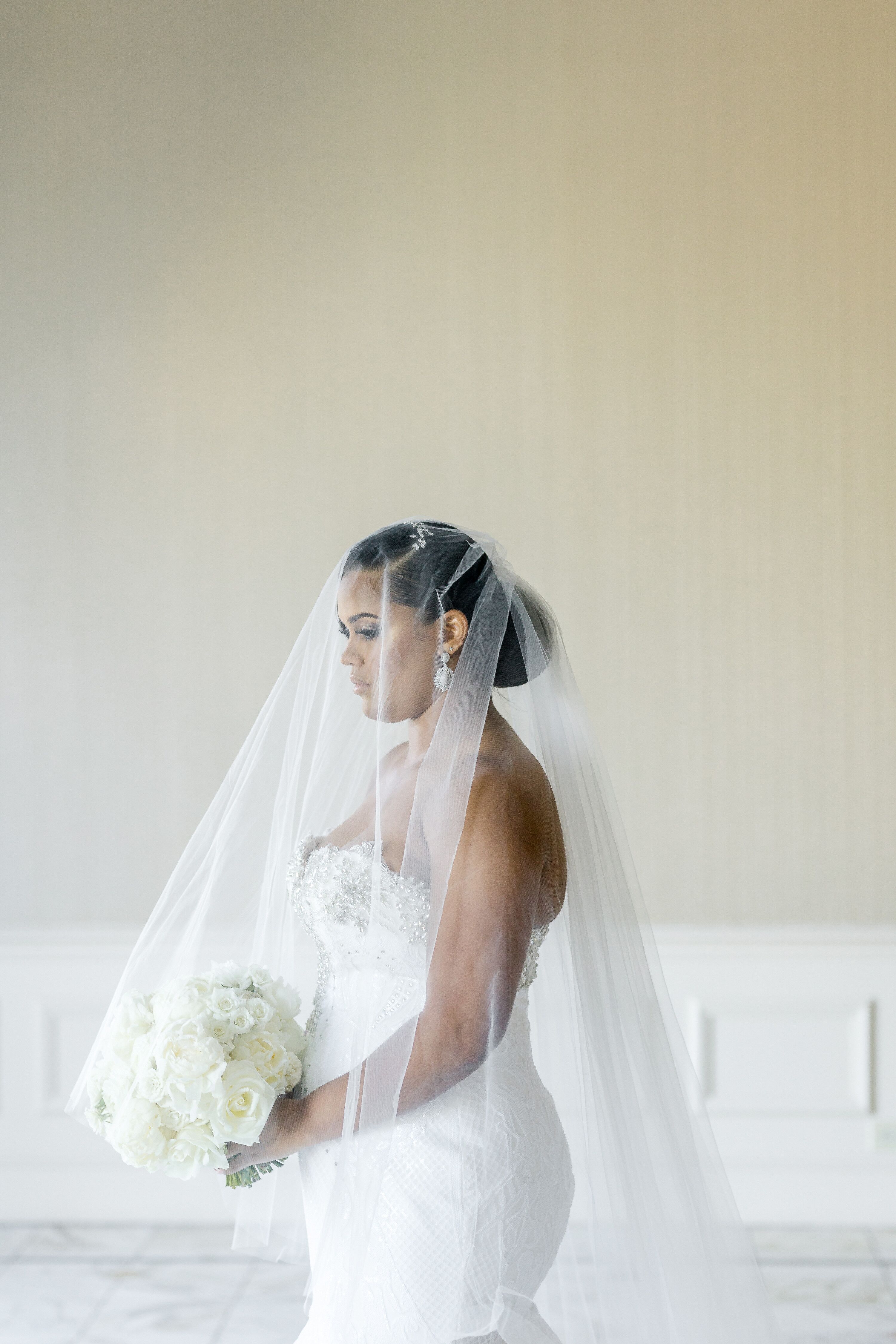 Bride With Long Veil Over Her Face Holding All-White Bouquet