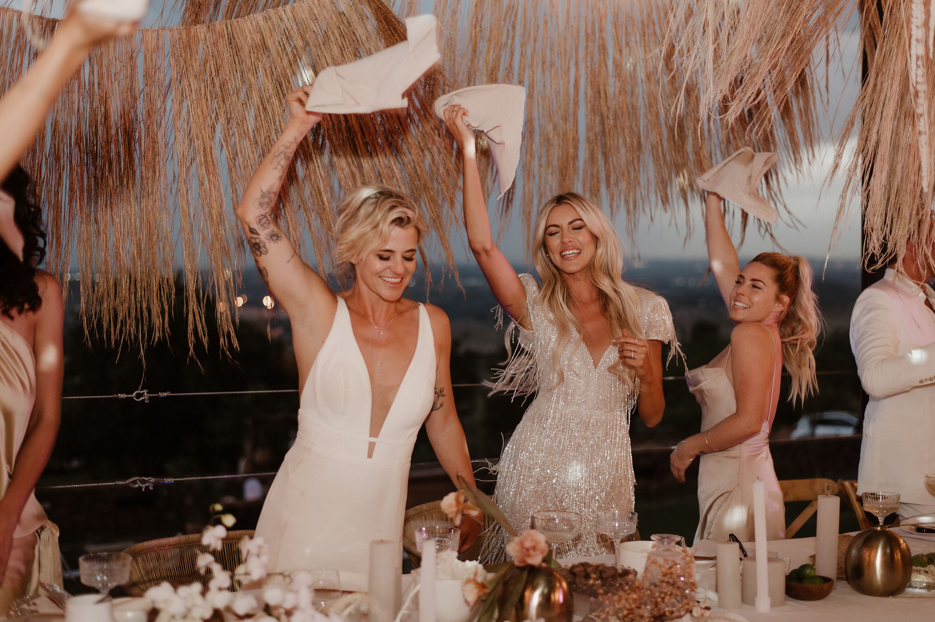 Brides in Different Dresses Waving Napkins Overhead With Guests Under ...