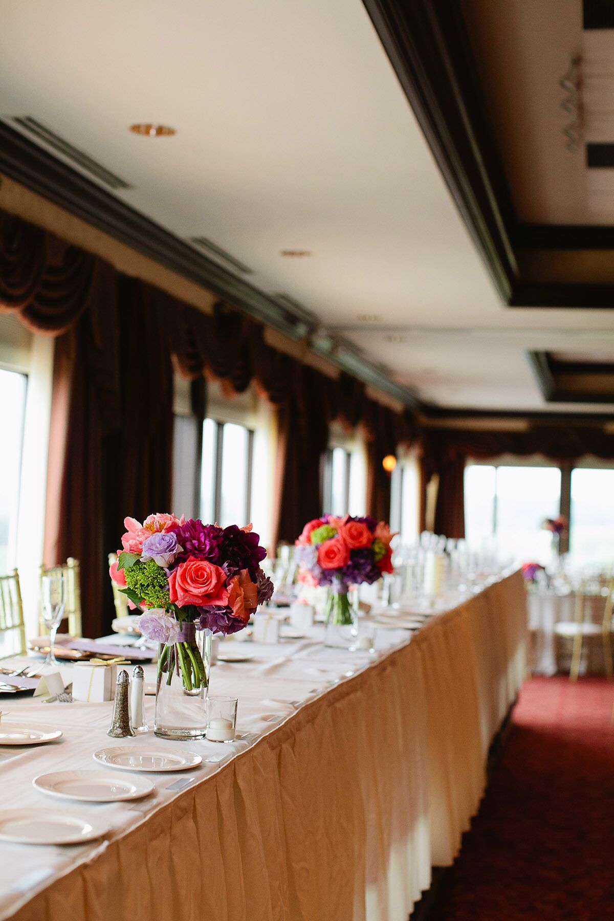 Long Rectangle Dining Table With Coral and Purple Centerpieces