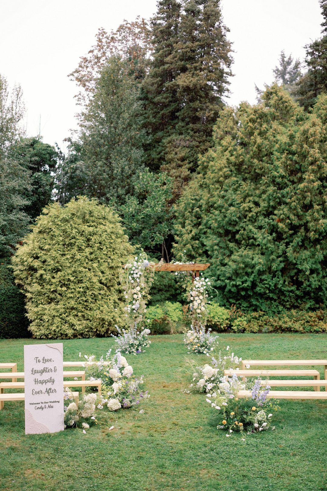 Outdoor Ceremony With Benches, Floral Arch and White Flower Displays