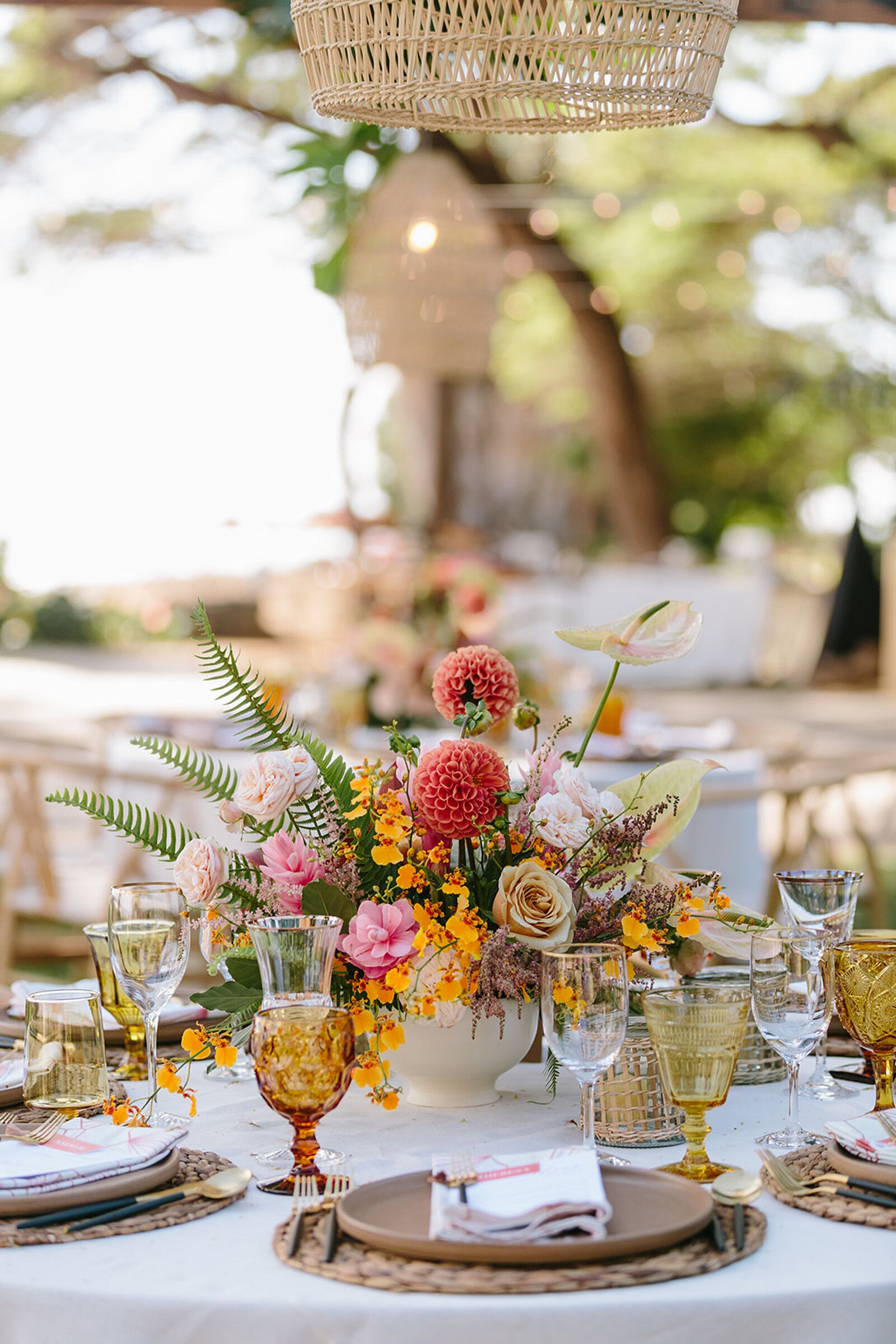 Colorful Low Floral Arrangement Goblets And Woven Place Mats At