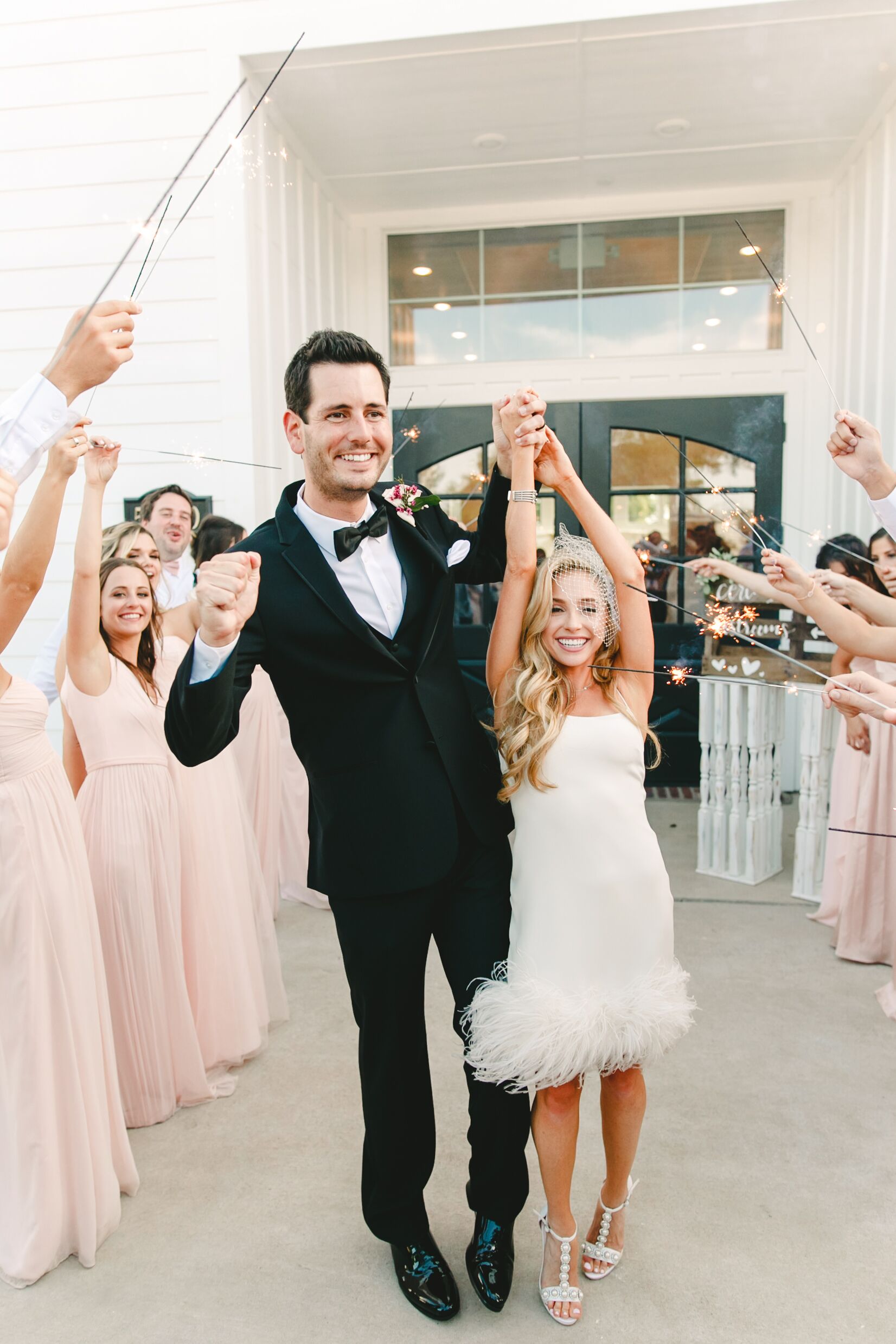 Formal Groom and Bride in Short, Feathered Dress Making Sparkler Exit