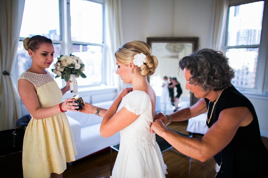 Bride Getting Ready in Curled Updo with White Floral Hair Accessory