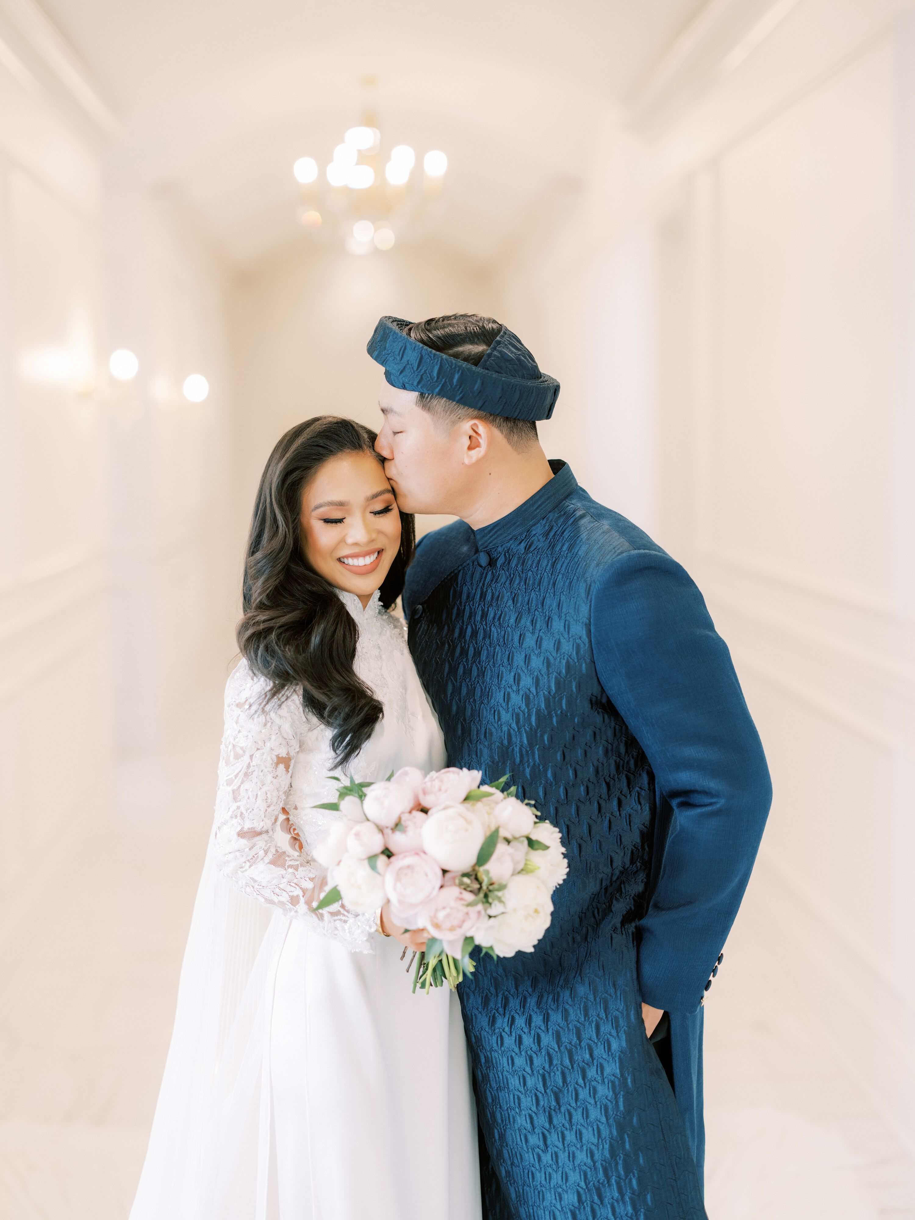 Groom in Navy Ao Gam Kissing Bride in White Ao Dai