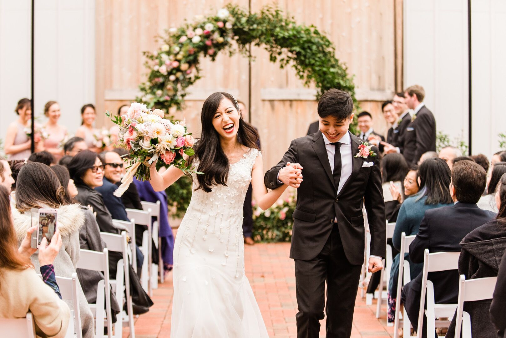 Bride and Groom During Recession From Circular Wedding Arch Covered in ...